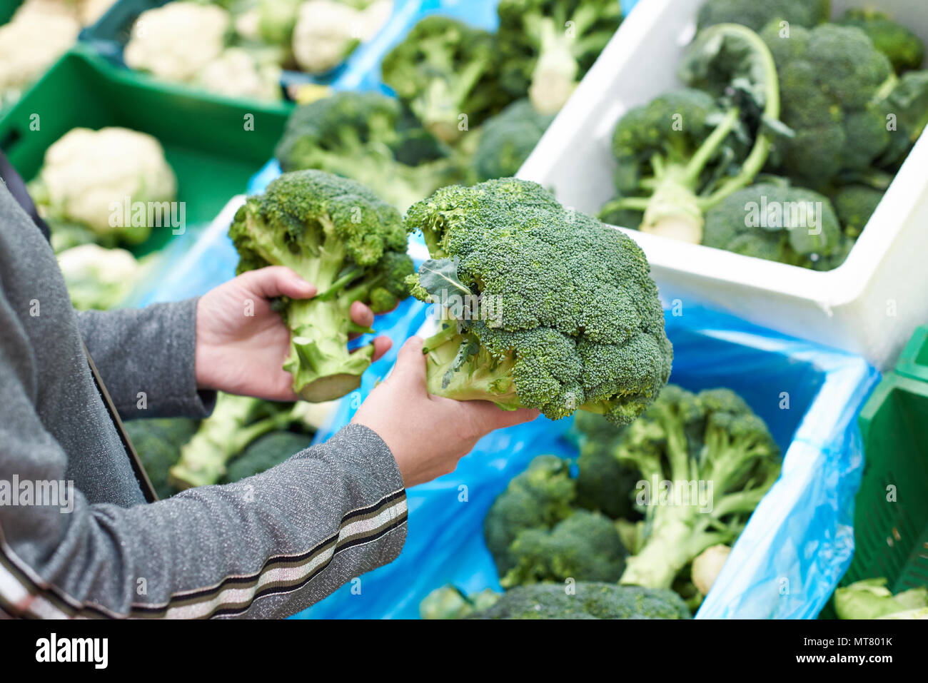 Woman buys broccoli in a grocery store Stock Photo - Alamy