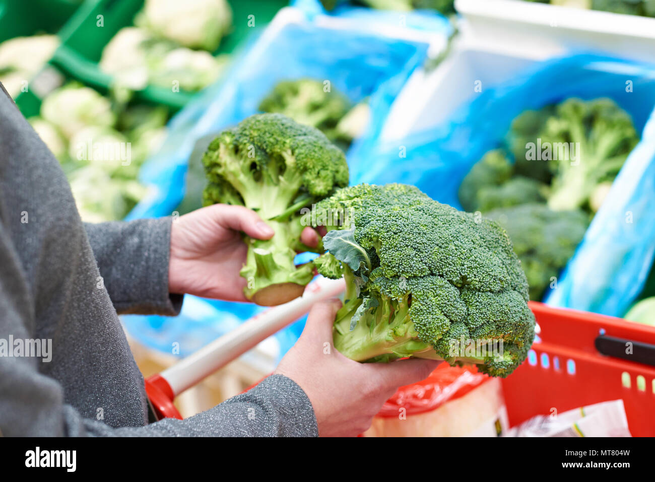 Woman buys broccoli in a grocery store Stock Photo - Alamy