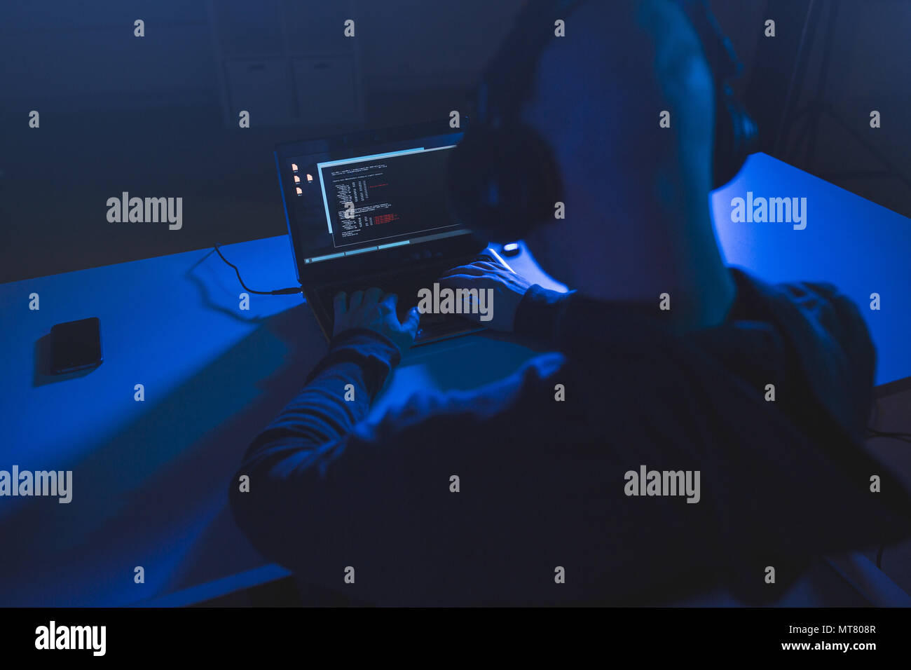 hacker with coding on laptop computer in dark room Stock Photo - Alamy