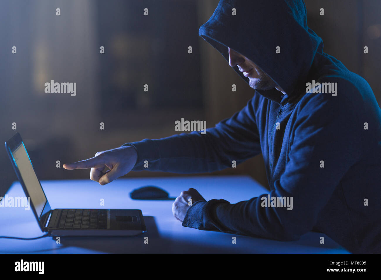 hacker pointing at laptop computer in dark room Stock Photo - Alamy
