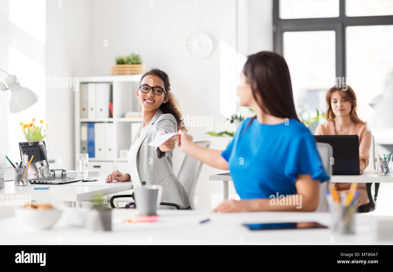 businesswomen giving each other papers at office Stock Photo - Alamy