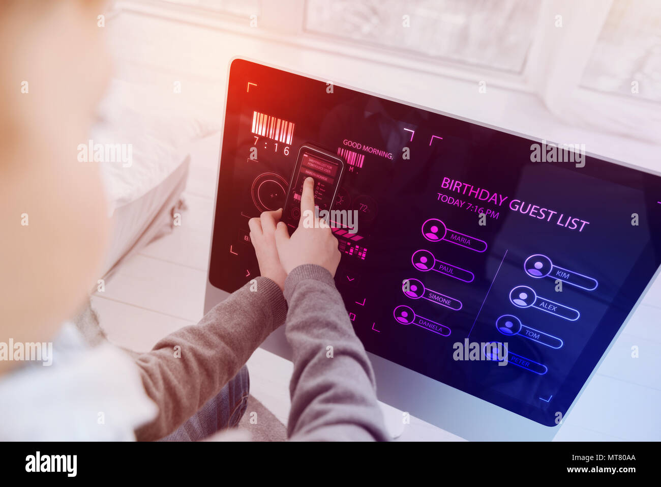 Clever boy sitting and pressing his smartphone to the screen of ...