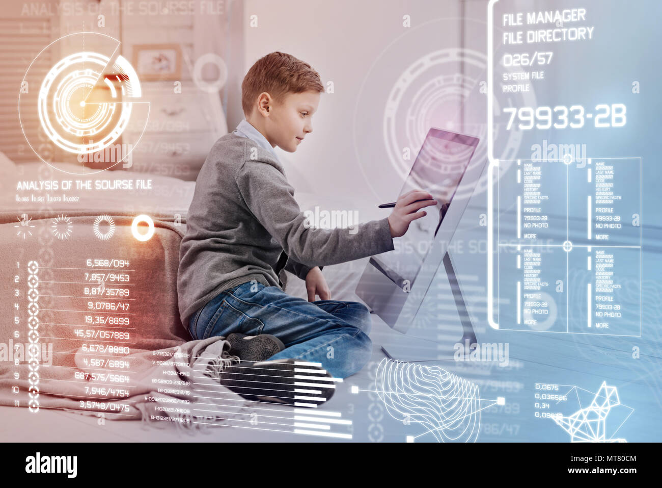 Careful child touching the screen of his device with a stylus while ...