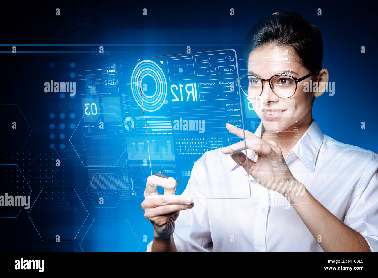 Cheerful web developer holding a transparent tablet and smiling Stock ...