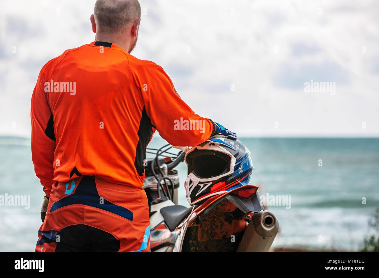 Motorcyclist stands behind his motorcycle hi-res stock photography and ...