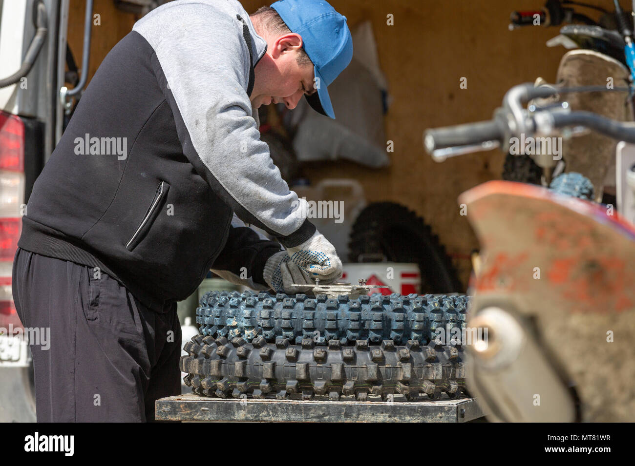 mechanic fixing motocycle wheel Stock Photo - Alamy
