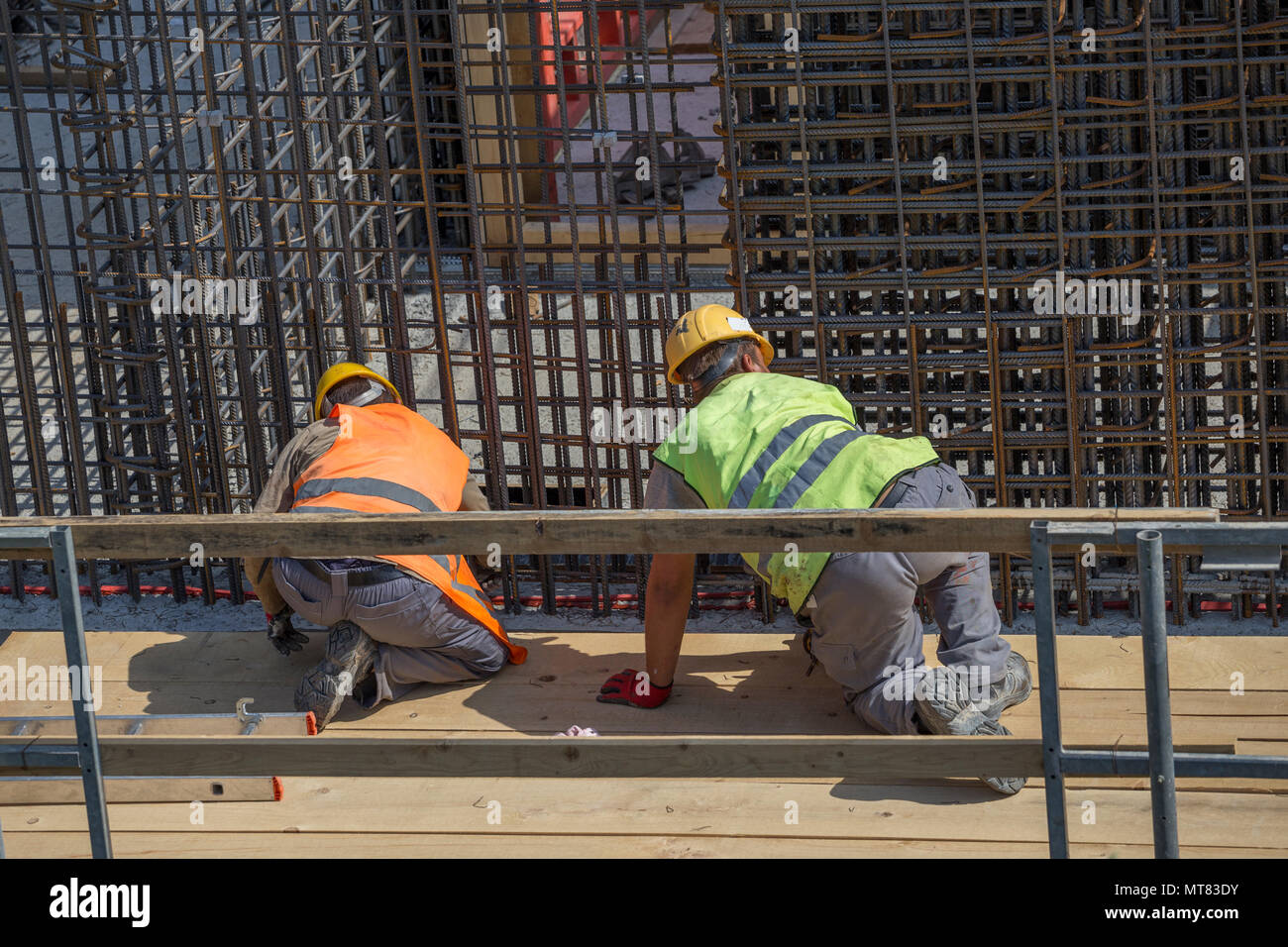 Construction workers tying rebar to make reinforcing frame for new ...