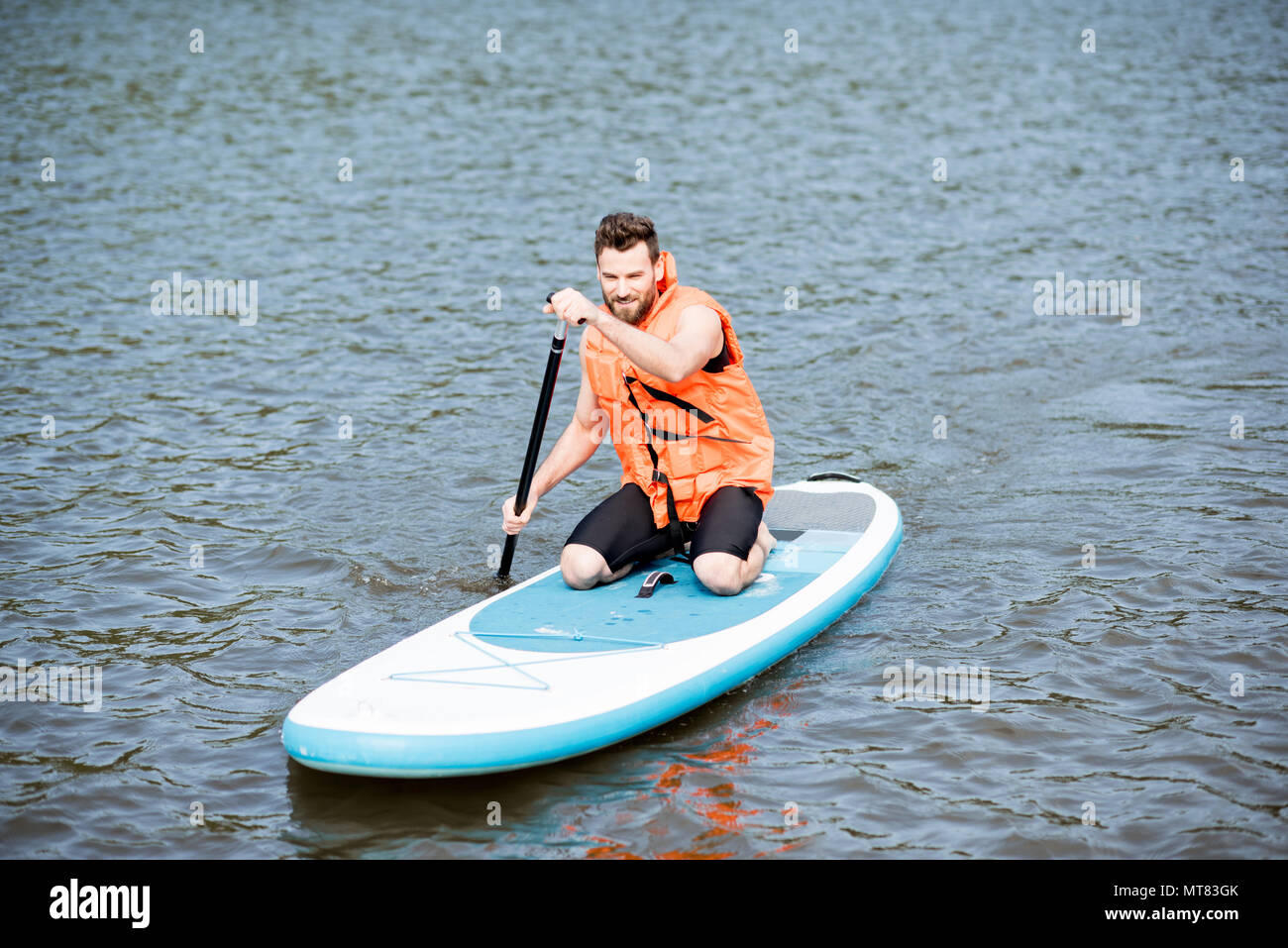 Man swimming on the paddleboard Stock Photo - Alamy