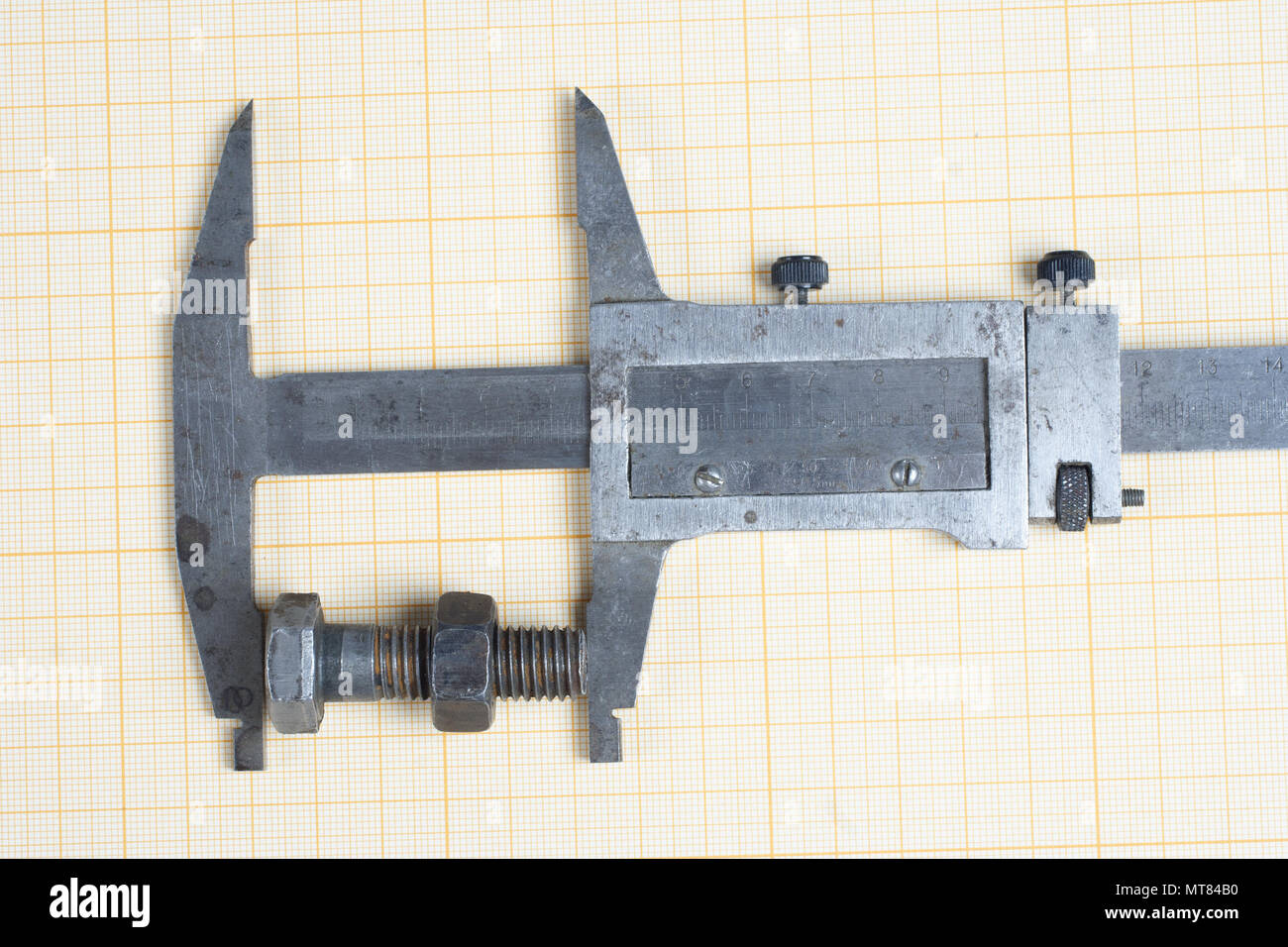 Screw, Nuts and caliper on graph paper background Stock Photo - Alamy