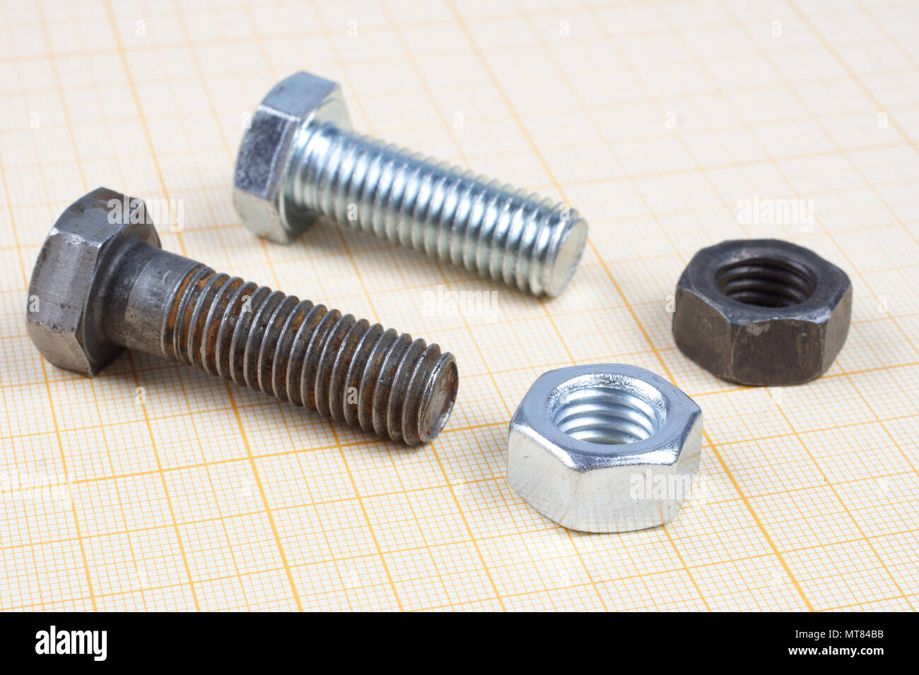 Screw and Nuts on graph paper background Stock Photo - Alamy