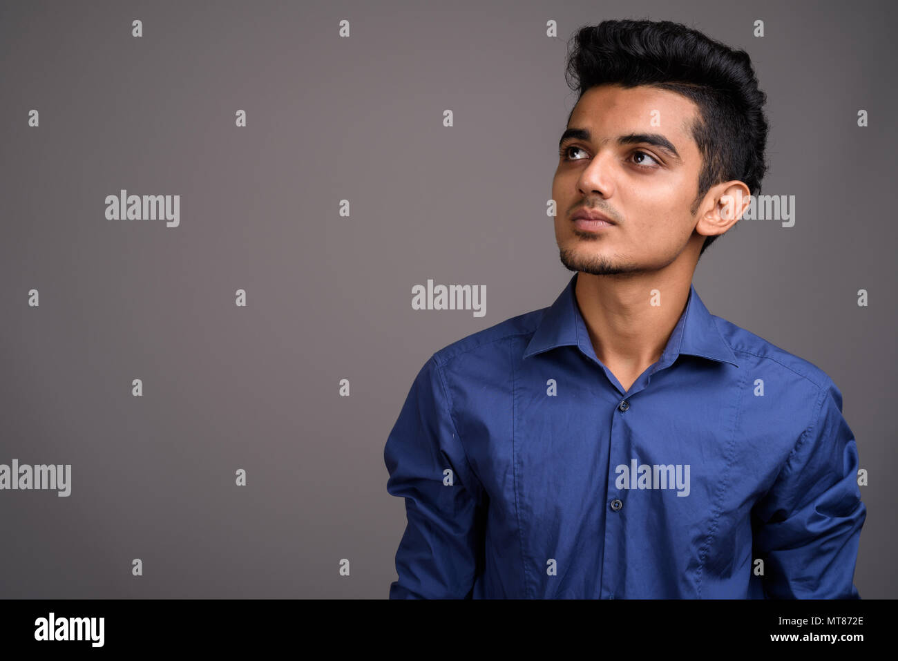 Young Indian businessman against gray background Stock Photo - Alamy
