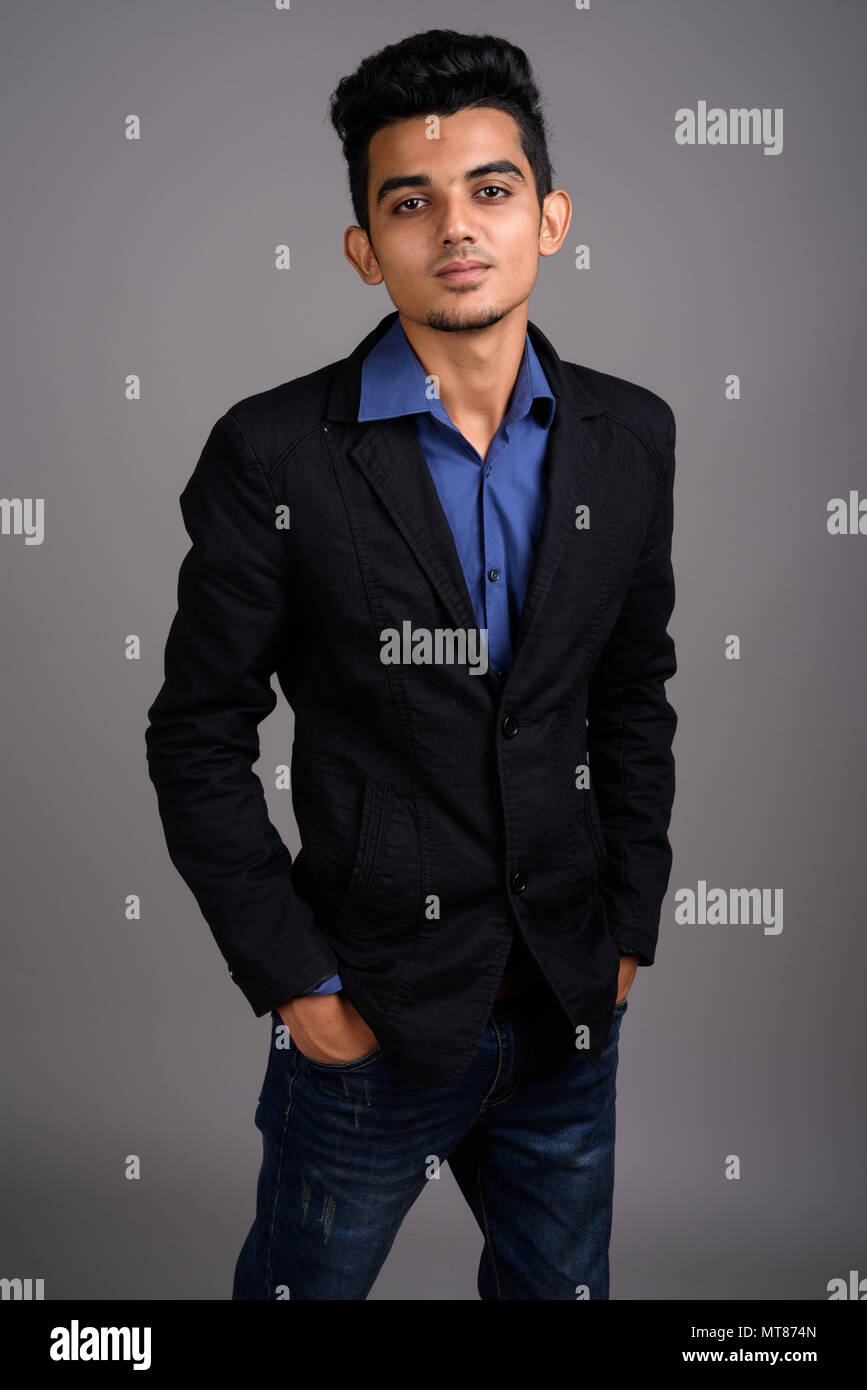 Young Indian businessman against gray background Stock Photo - Alamy