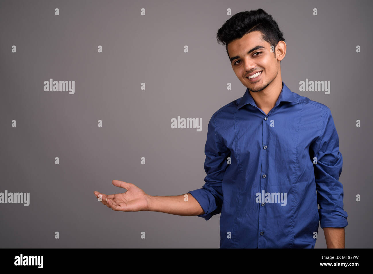 Young Indian businessman against gray background Stock Photo - Alamy