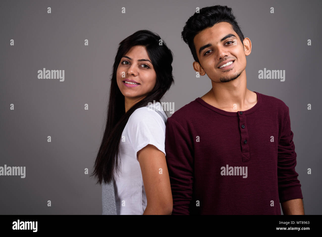Young Indian man and young Indian woman together against gray ba Stock ...