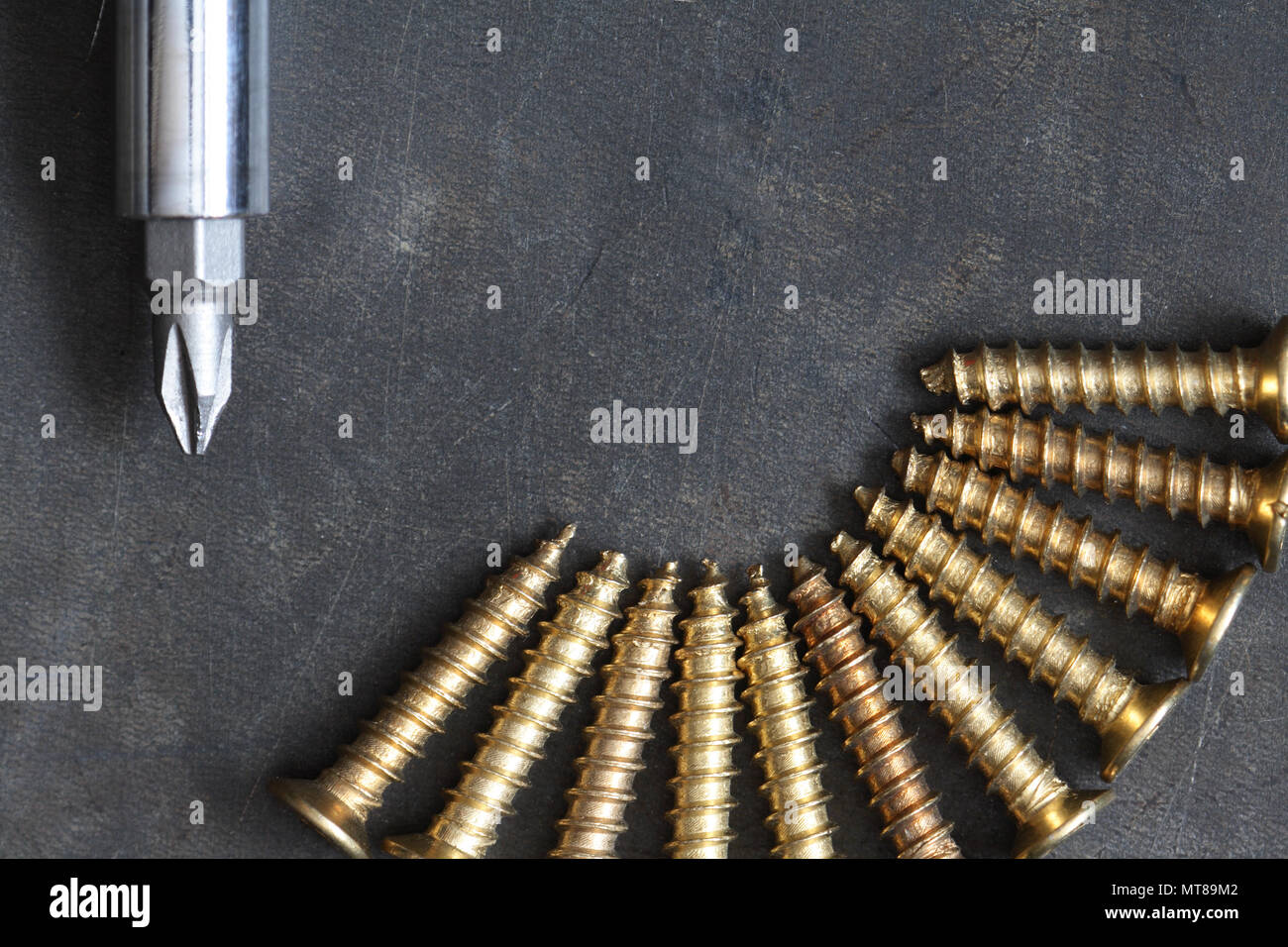 Closeup of screwdriver and screws on dark metal background Stock Photo ...