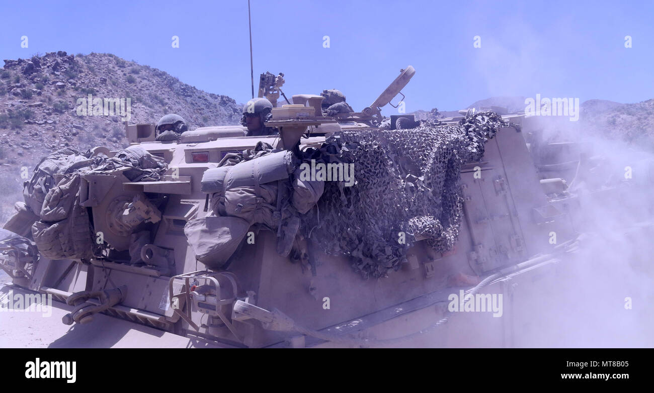 A tank crew cautiously guides an M88 Recovery Vehicle through a narrow ...