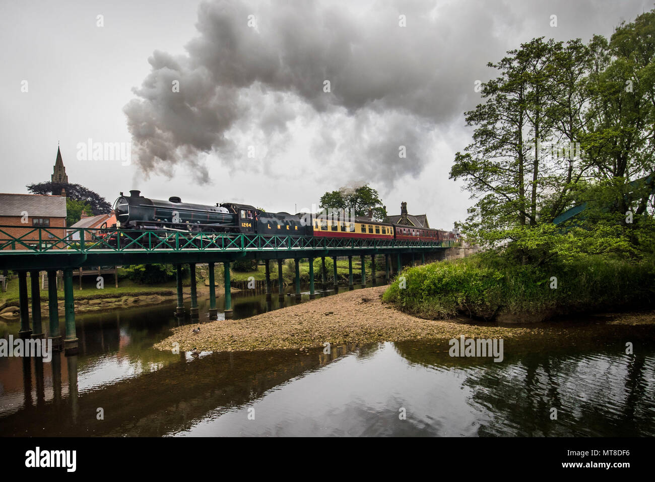 The LNER 1264 steam locomotive passes over the River Esk in Ruswarp on ...