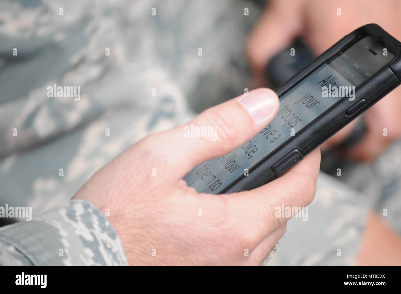 An Airman uses his smart phone to follow along with a presentation ...