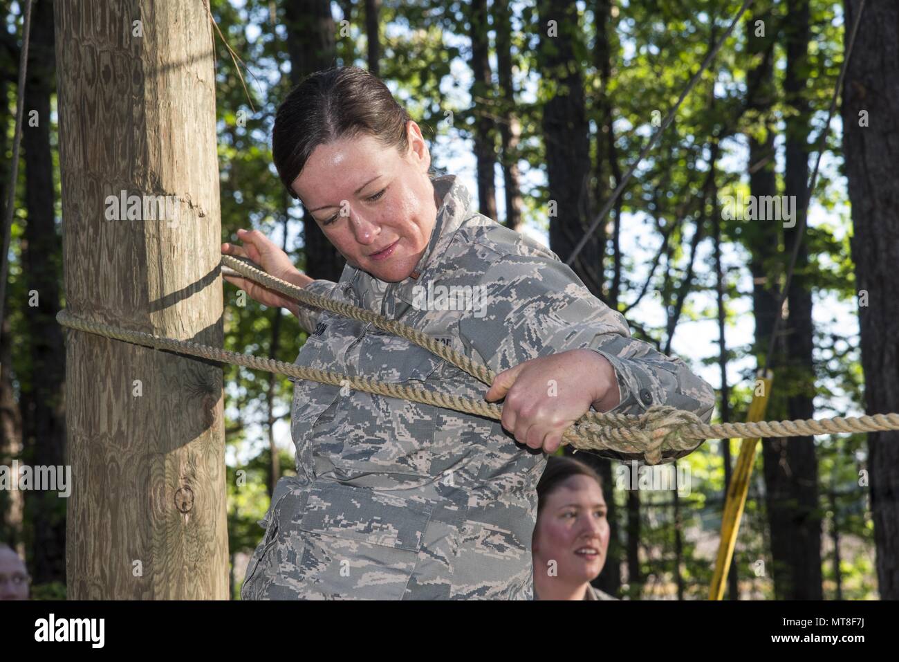 Commissioned Officer Training students balances across a rope obstacle ...