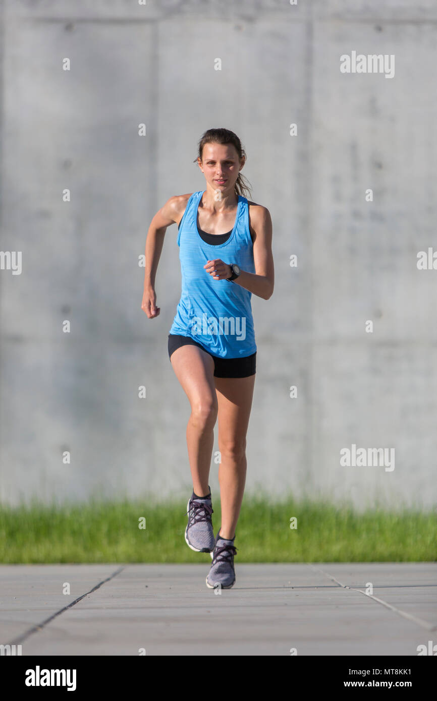 Female Urban Runner running toward the viewer Stock Photo - Alamy