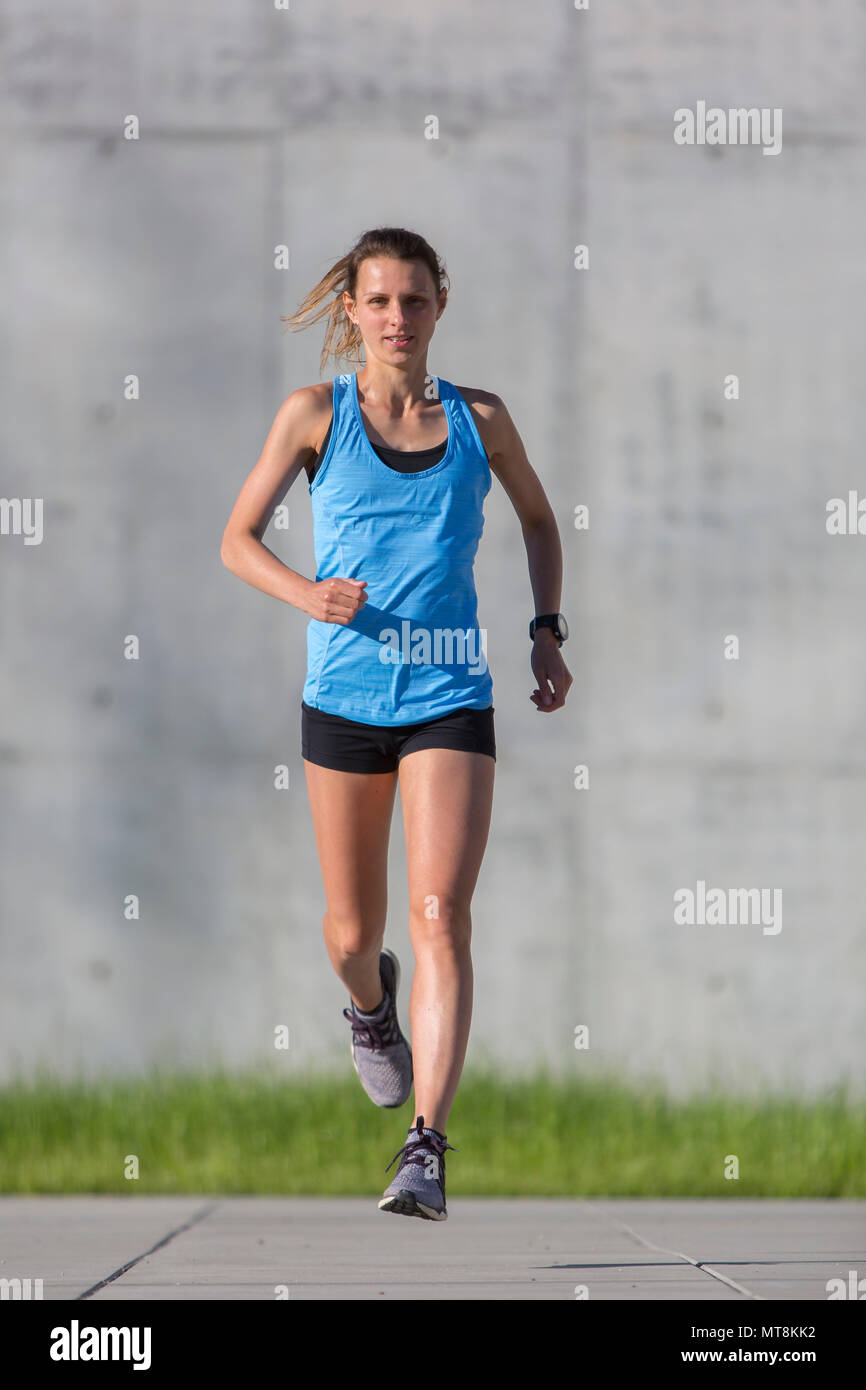 Female Urban Runner running toward the viewer Stock Photo - Alamy