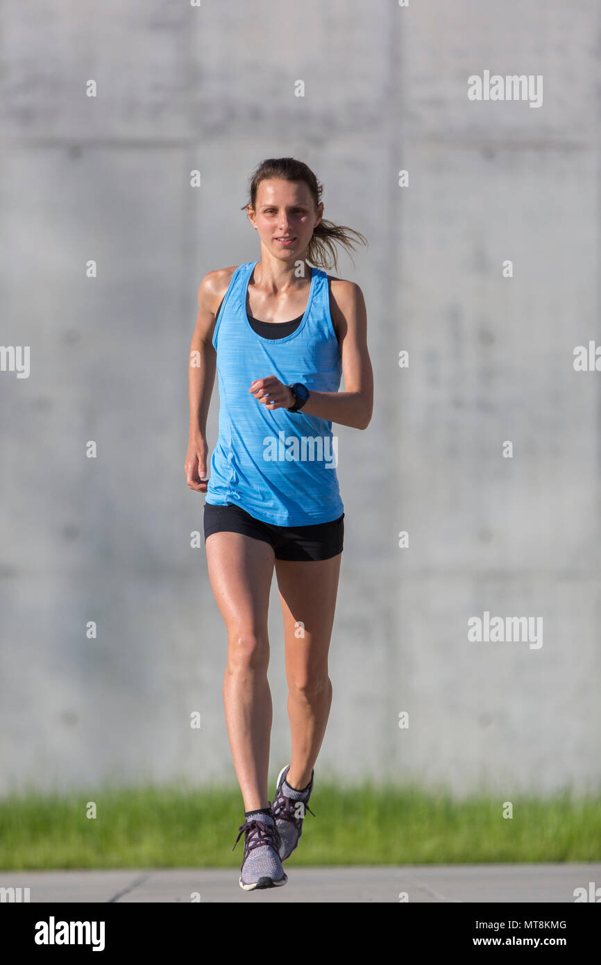 Female Urban Runner running toward the viewer Stock Photo - Alamy