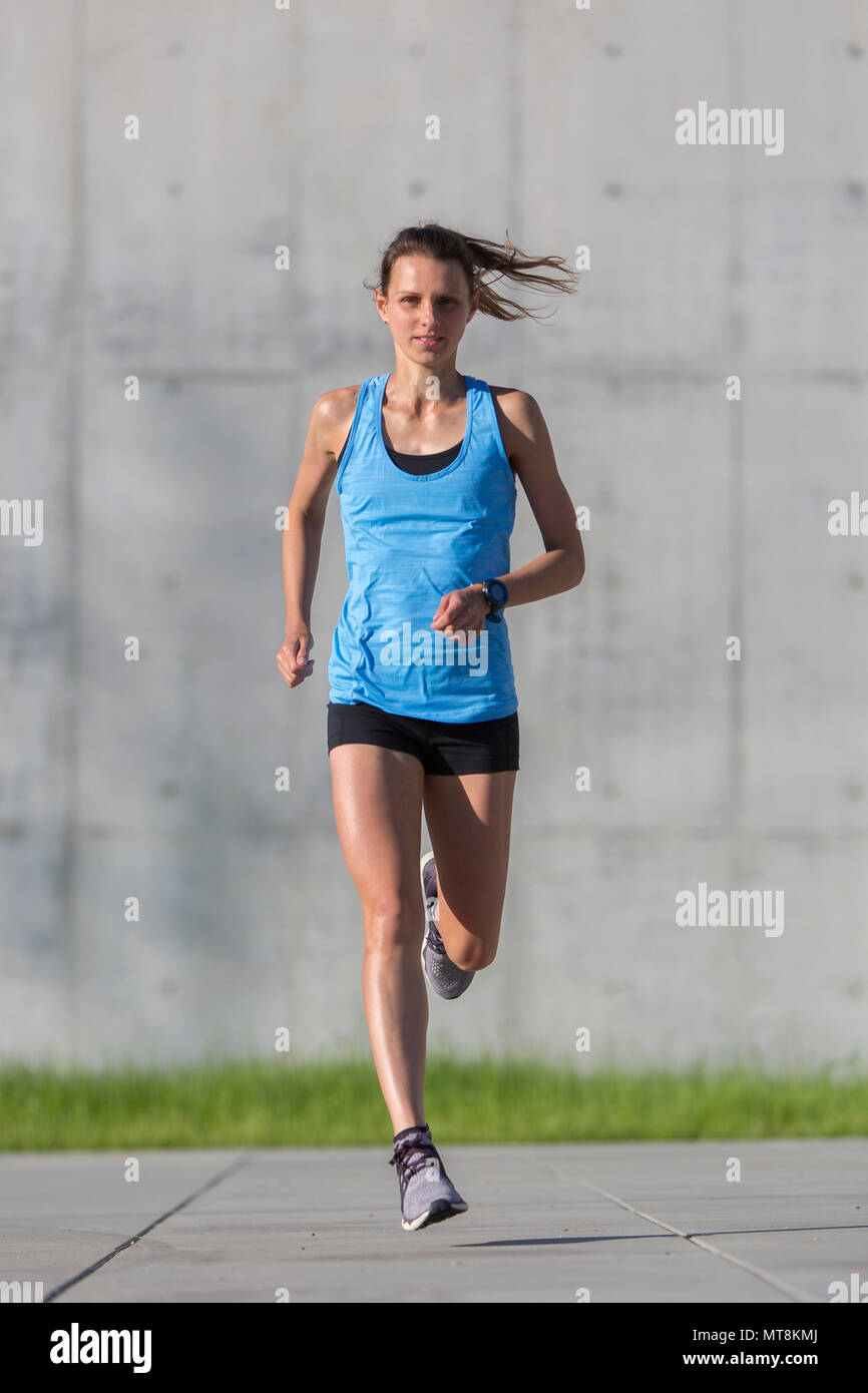 Female Urban Runner running toward the viewer Stock Photo - Alamy