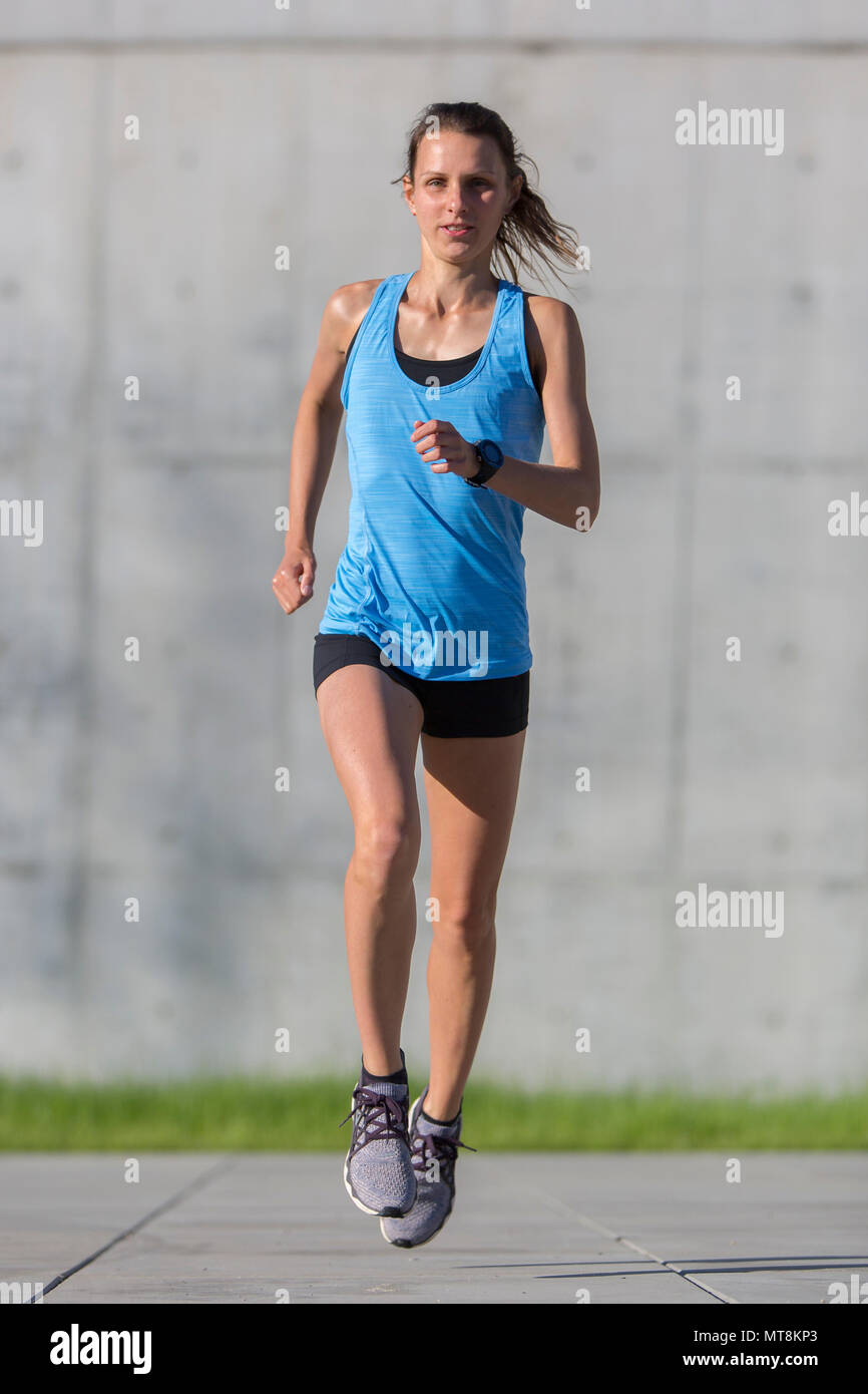 Female Urban Runner running toward the viewer Stock Photo - Alamy