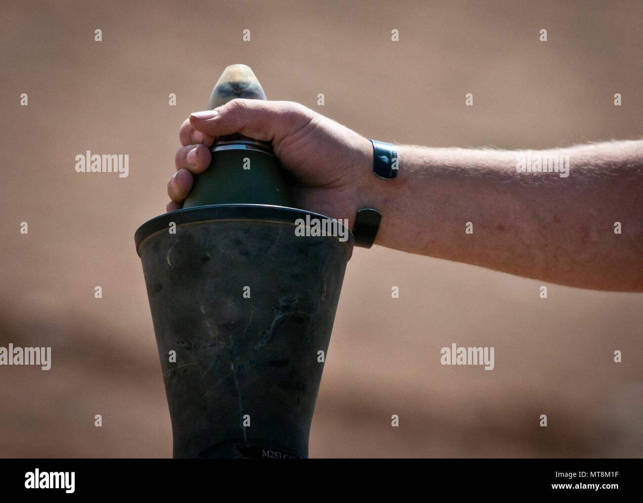 A Coalition advisor hangs an 81-millimeter mortar prior to launching it ...