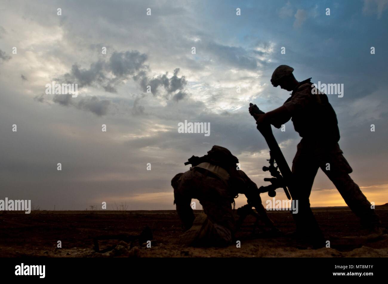 A Coalition member hangs an 81-millimeter mortar prior to launching it ...