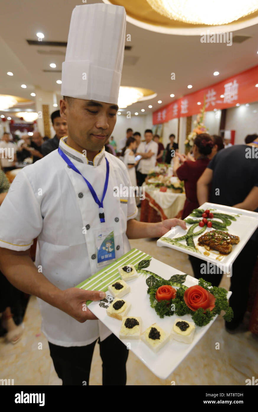 Linyi. 28th May, 2018. A chef presents his dishes during a cooking ...