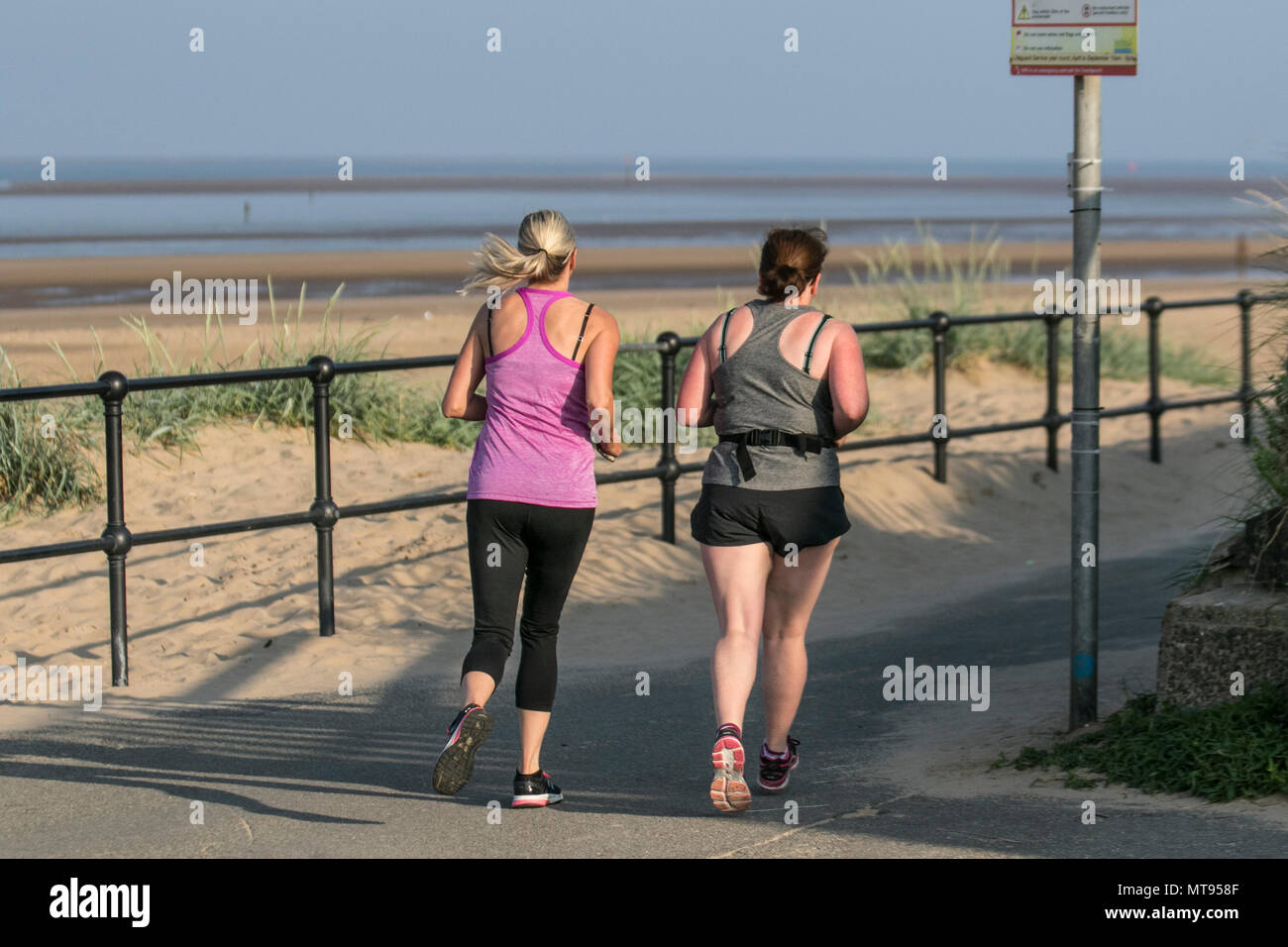 Woman running on the seafront promenade at Crosby, Liverpool. 29th May ...