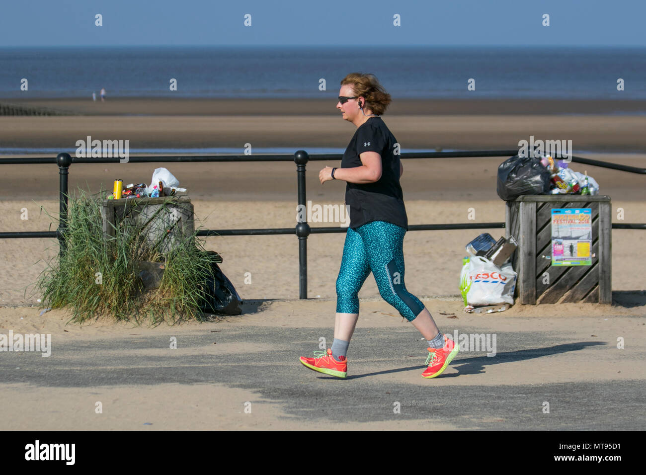 Woman running on the seafront promenade at Crosby, Liverpool. May, 2018 ...