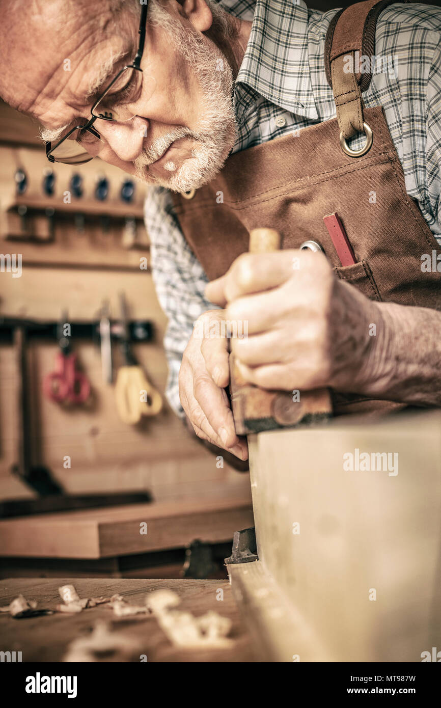 old carpenter uses a planer Stock Photo - Alamy