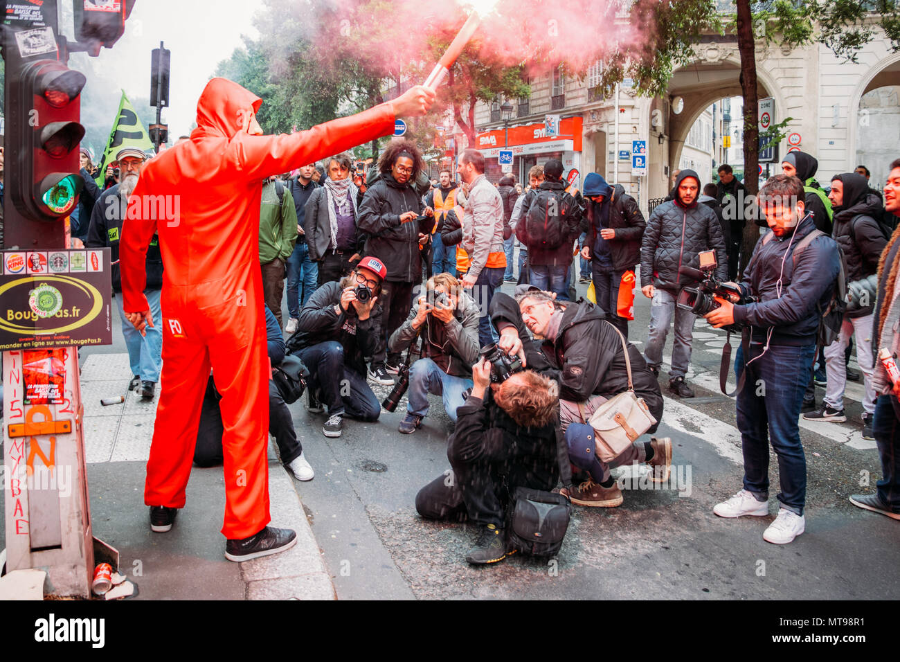 Protestors wearing a Guy Fawkes mask light gas canisters to express ...
