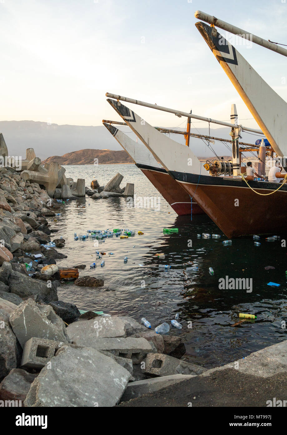Pollution in the sea in front of dhows in the port, Dhofar Governorate ...