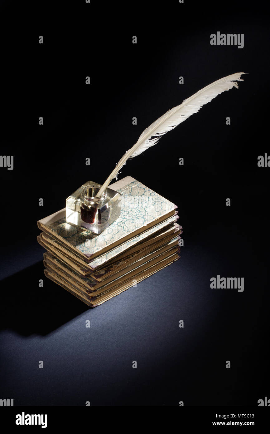 Old fountain pen, books and inkwell on a black background Stock Photo ...