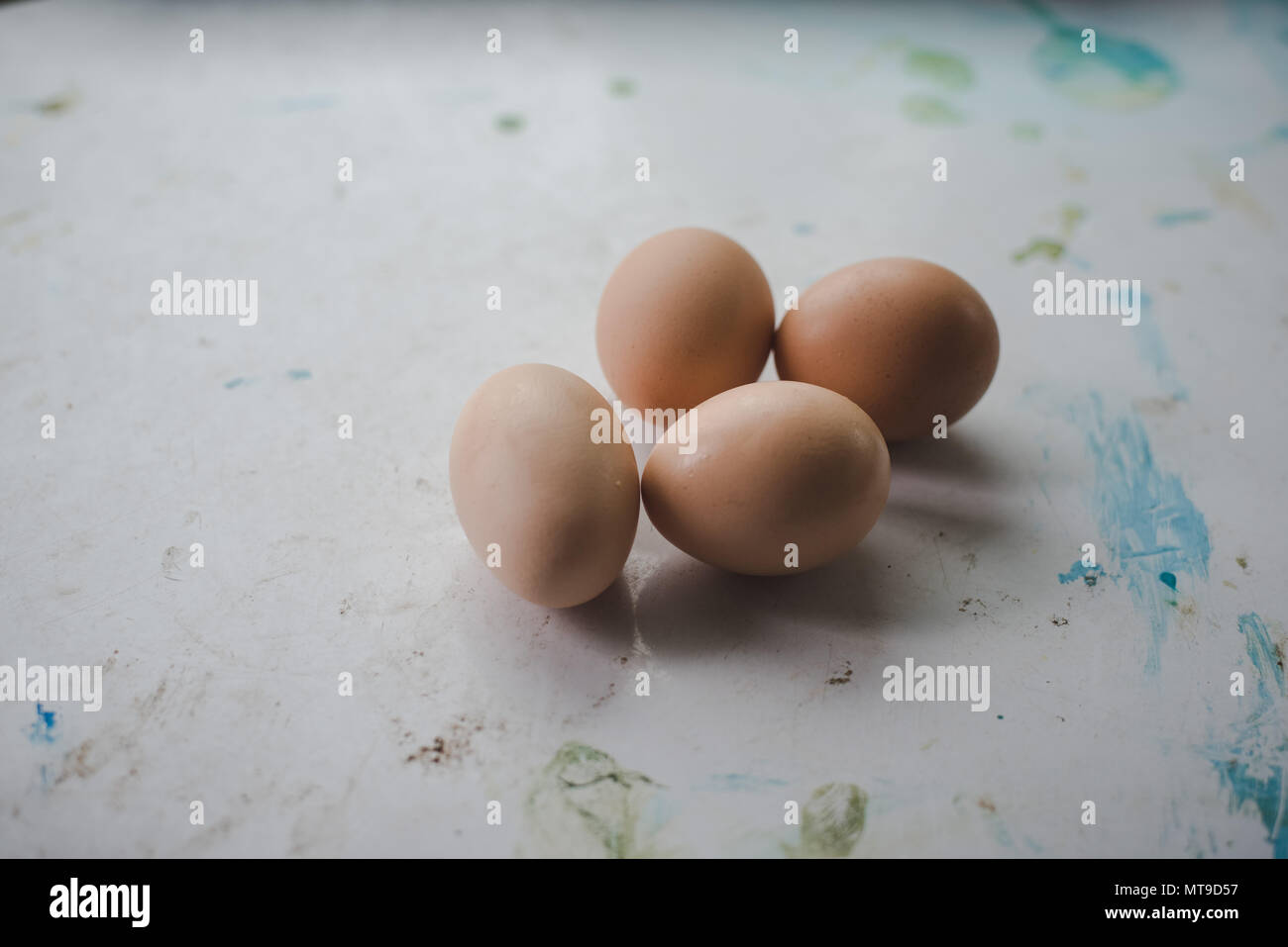 Four farm fresh eggs sitting on a counter Stock Photo - Alamy