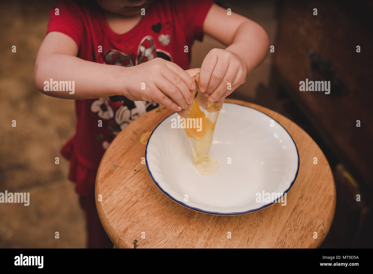 A toddler cracking a farm fresh egg into a bowl Stock Photo - Alamy