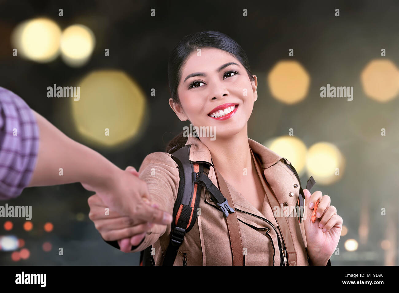 Happy asian tourist woman follow the husband hand with blur lights ...