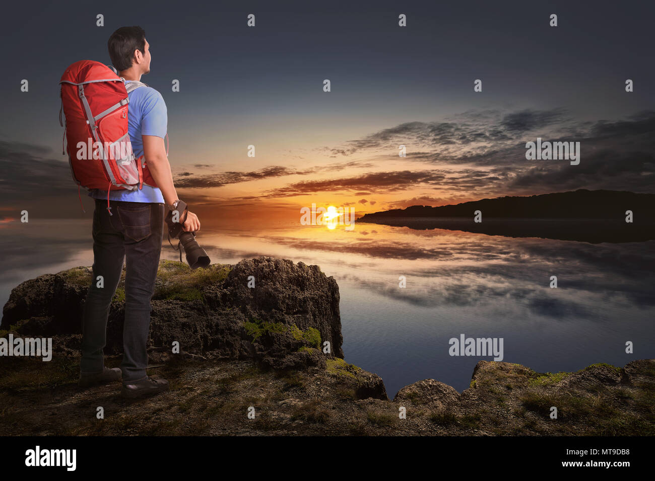 Back view of asian tourist man with camera and backpack looking at ...
