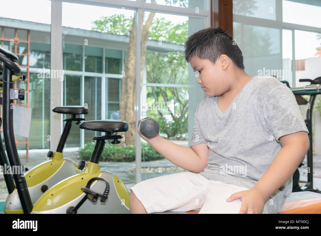 Obese fat boy Lifting dumbbell in fitness room,Exercise to lose weight ...