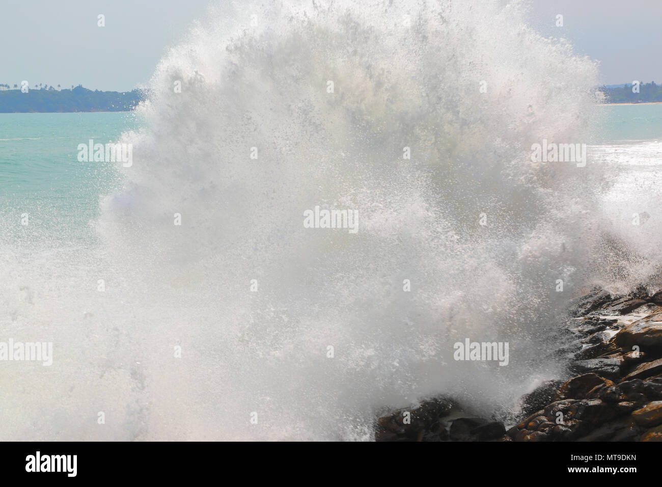 big wave breaking on rocks Stock Photo - Alamy