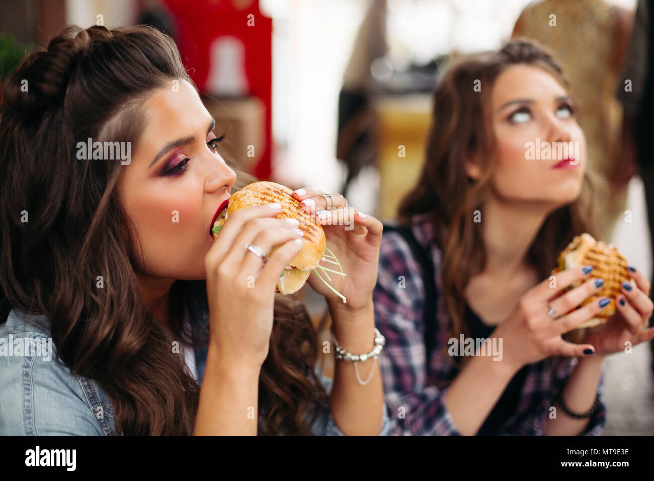 Teen girls enjoying burgers in cafe Stock Photo - Alamy