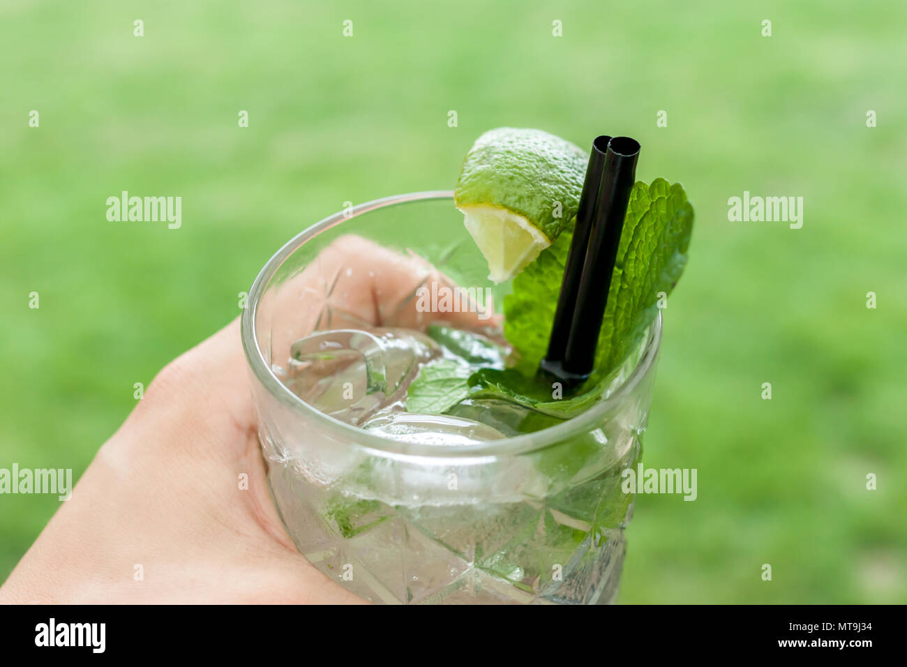 glass of mojito in male hand Stock Photo - Alamy