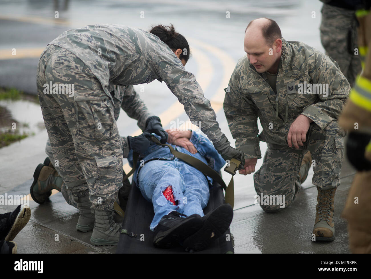 Emergency response personnel prepare a victim of a simulated plane ...