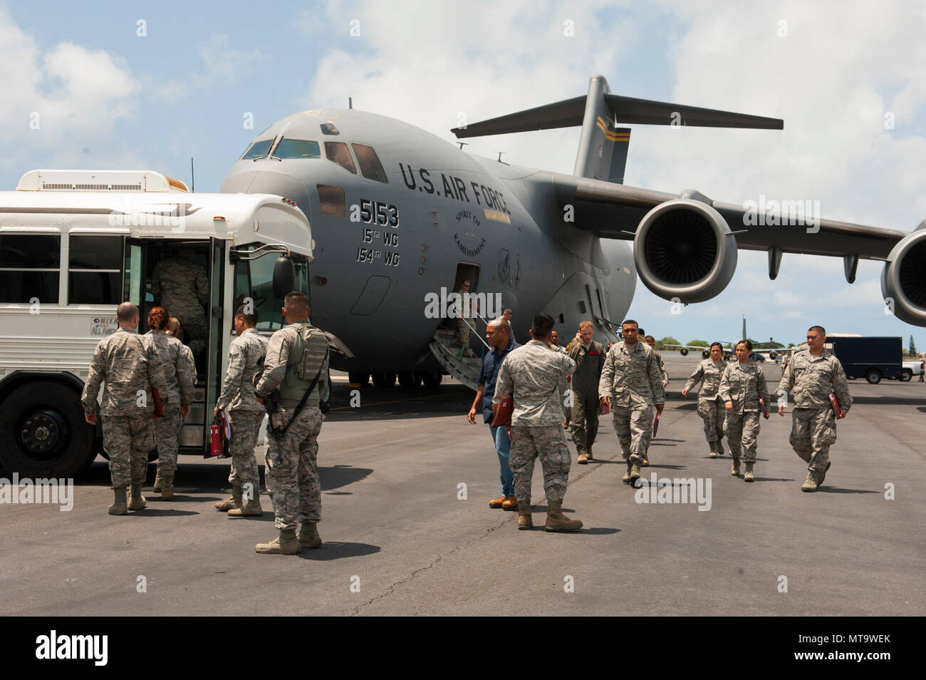 Airmen disembark a C-17 Globemaster III and load onto a bus headed for ...