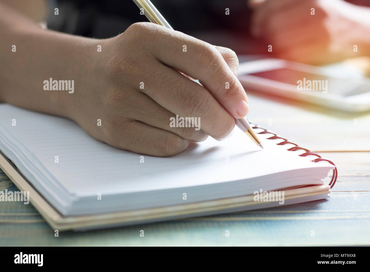 hand of people, student writing and note on notebook on wood table with ...