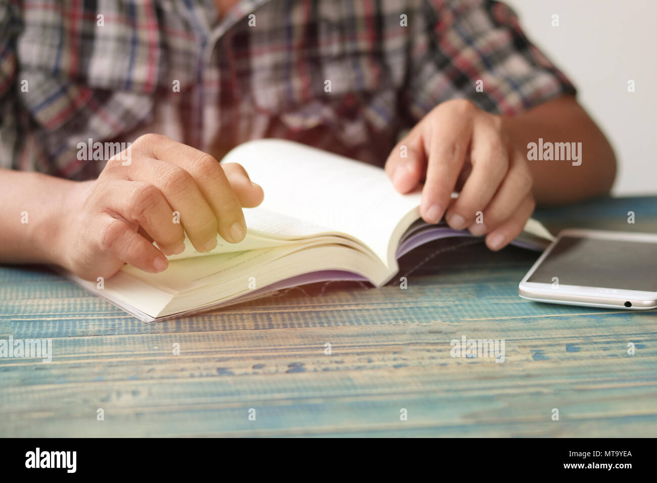 hand of people, student opening and reading text book on wood table ...
