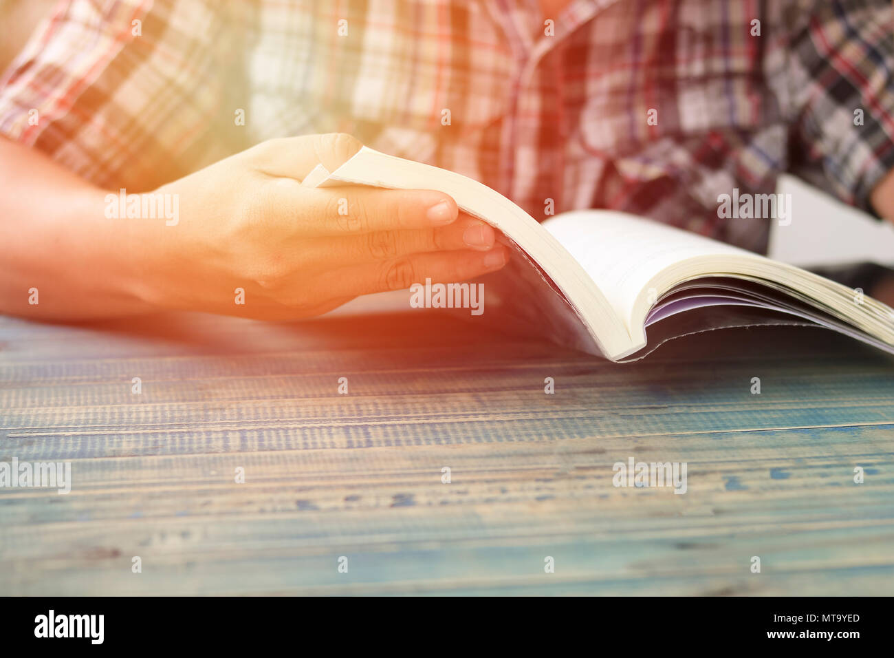 hand of people, student opening and reading text book on wood table ...